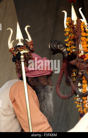 A sadhu from the Juna Akadha smoke opium at their camp during the Ardh ...