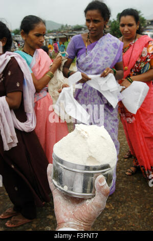 Slum dwellers stand in queue to collect relief materials distributed by ...