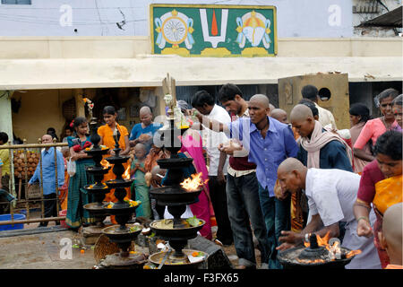 Devotees worshipping and offering coconut, camphor and flowers to Lord ...