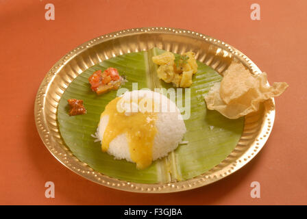 Vegetarian ; Indian food varan bhat rice pickles and puri on banana ...