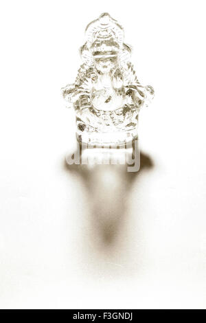 Crystal glass idol of lord Ganesh elephant headed god with shadow on ...