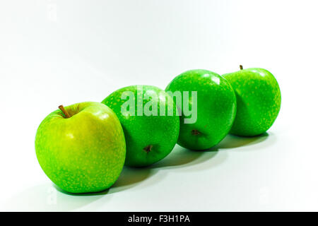 four green apples on white background Stock Photo - Alamy