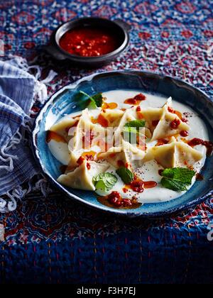 Turkish Manti with red pepper, tomato sauce, yogurt and mint. Plate of ...
