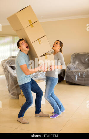 Young man Falling Stack Of Cardboard Boxes Over back In House while ...