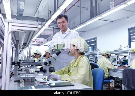 Supervisor overseeing quality check station factory producing flexible ...