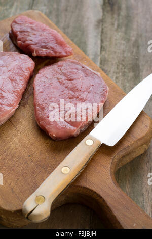 Portion of raw beef meat on dark butcher board Stock Photo - Alamy