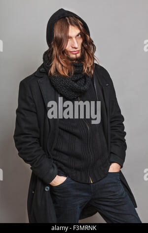 Handsome man wearing winter coat looking at the camera smiling with ...
