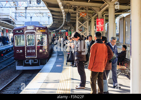 Japan, Osaka, Hankyu Express at platform in Umeda station. People ...