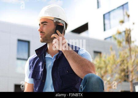 View of a Yong attractive worker using mobile phone on a construction ...
