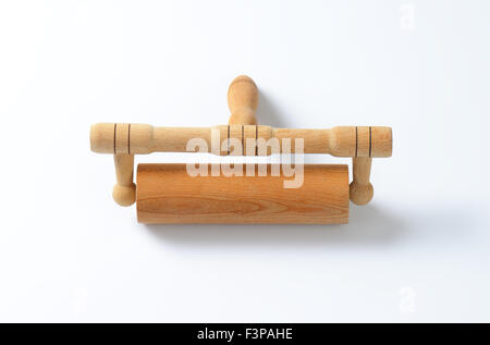 new wooden rolling pin on a red textile napkin and open notebook ...