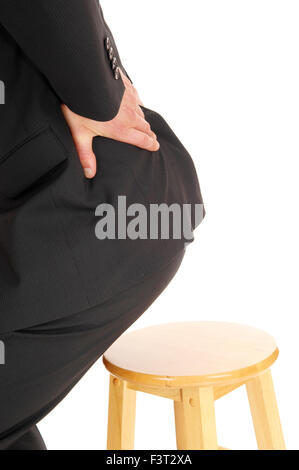 Man with back pain getting up from chair Stock Photo - Alamy