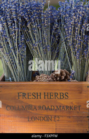 dried lavender flowers in a wooden bowl on a light concrete background ...
