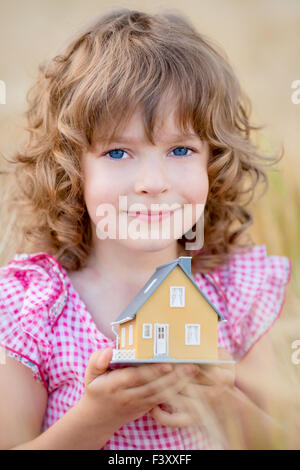 Hands of real estate agent holding house model on light background with ...