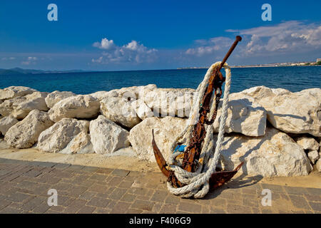 Old rusty anchor on rock by blue sea Stock Photo - Alamy