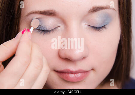 Makeup artist applies eye shadow. Perfect smooth skin.Applying makeup ...