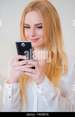 Portrait of beautiful blond woman using cellphone Stock Photo - Alamy