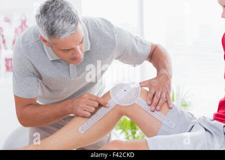 Doctor examining man leg Stock Photo - Alamy
