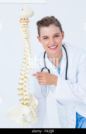 Smiling doctor pointing an anatomical spine Stock Photo - Alamy