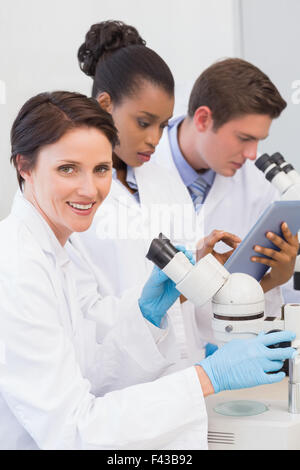 African woman biochemist using microscope in modern equipped laboratory. Black scientist doctor ...
