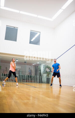Couple playing a game of squash Stock Photo - Alamy