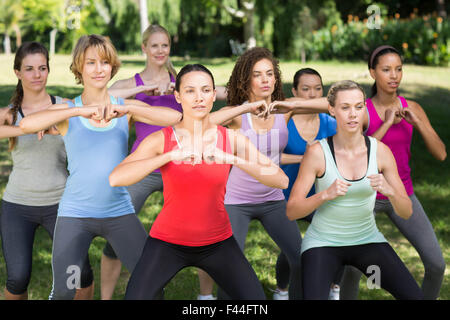 Fitness group squatting in park Stock Photo - Alamy
