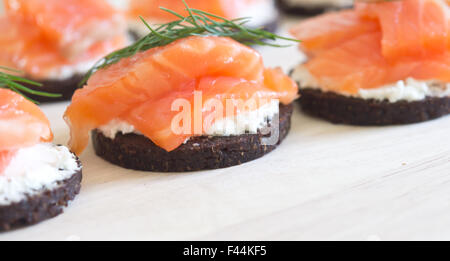 Wooden board with delicious canapes on color table Stock Photo - Alamy