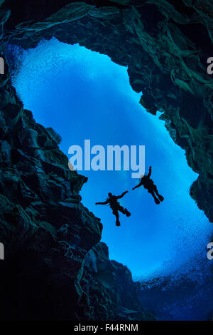Pair divers floating in Silfra Canyon deep fault filled fresh water in ...