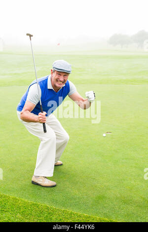 Happy golfer cheering on putting green at eighteenth hole Stock Photo ...