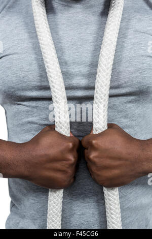Athletic young man with battle rope doing exercise in functional ...