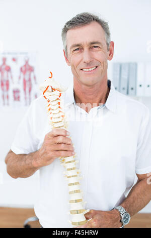 Smiling doctor showing anatomical spine Stock Photo - Alamy