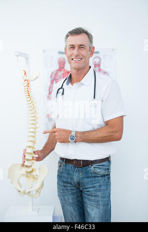 Smiling doctor showing anatomical spine Stock Photo - Alamy