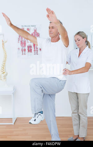 Female doctor and a mature man raising crutches and recovering from ...