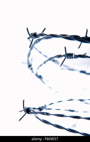 A vertical shot of a sharp and dangerous barbed wire fence in a blurred ...