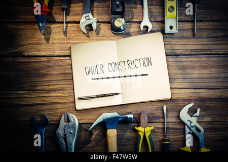 Under construction against desk with tools Stock Photo - Alamy