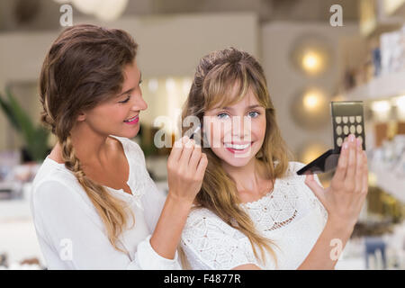 Employee applying makeup on costumer Stock Photo - Alamy