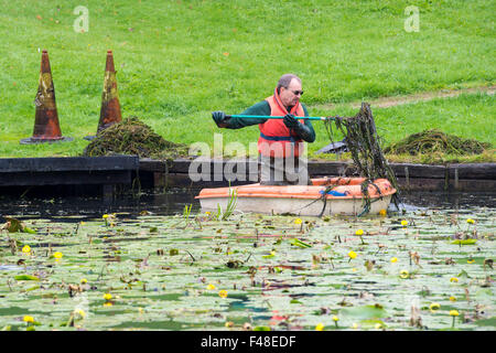 Park Ranger Graham Lister clears weed from the community pond at ...