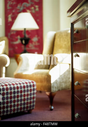 Interior of room with armchair, chest of drawers, folding screen and ...