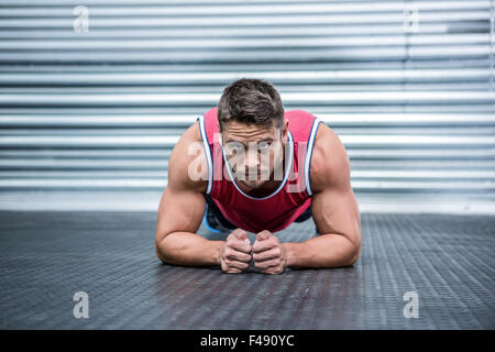 Portrait of muscular man in plank position Stock Photo - Alamy