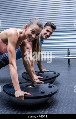Muscular couple doing bosu ball exercises Stock Photo - Alamy