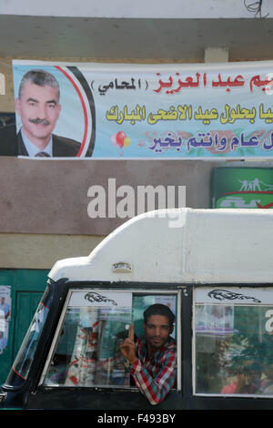 Minya, Egypt. 15th Oct, 2015. Egyptians walk by a wall where posters of ...