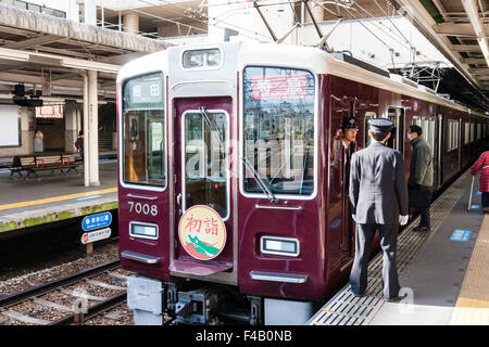 Japan, Hankyu private railway. Express maroon train arriving at ...