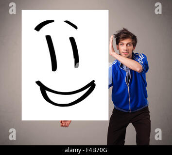 Young boy holding smiley face drawing Stock Photo - Alamy