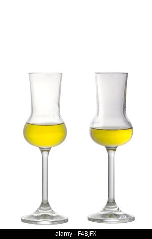 Grappa still life with two filled glasses, open decanter and green ...