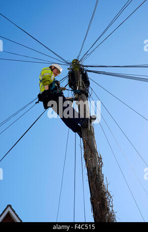telecoms engineer working from telegraph pole uk Stock Photo - Alamy