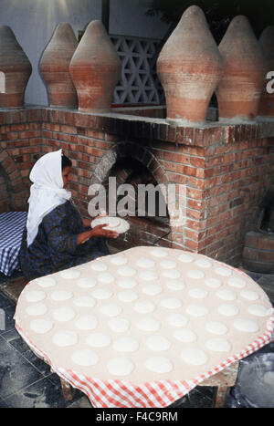 An Egyptian woman preparing dough to make bread in a Nile side village ...