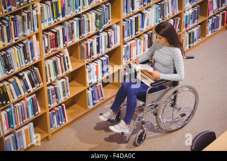 Disabled student reading book sitting on wheelchair Stock Photo - Alamy
