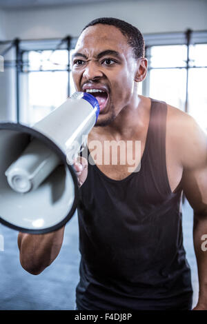 Muscular man yelling through a megaphone Stock Photo - Alamy