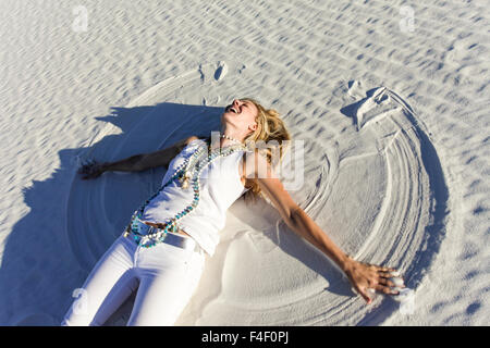 Girl making angel in sand on beach, high angle view Stock Photo - Alamy
