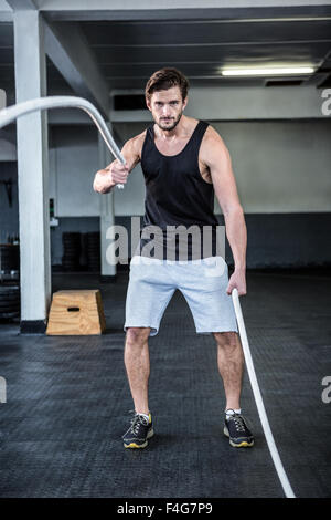 Fitness man working out with battle ropes at gym Stock Photo - Alamy