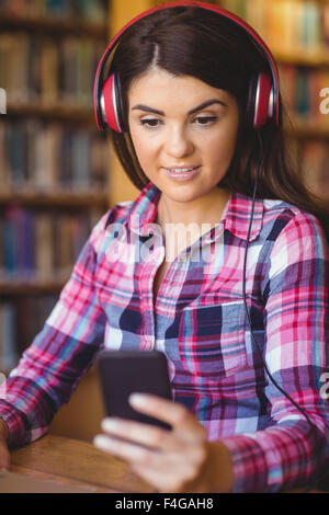 Beautiful female student with headphones listening to music Stock Photo ...